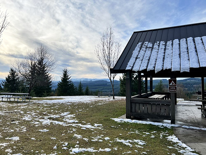 Winter transforms the hilltop viewpoint into a snow-dusted postcard. The covered shelter says, "Yes, we know it rains in Oregon."