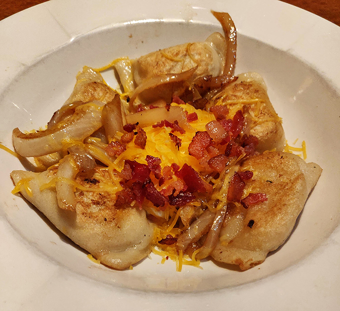 Behold the stars of our show: golden pierogies crowned with caramelized onions, crispy bacon bits, and melted cheddar that whisper, "Resistance is futile.