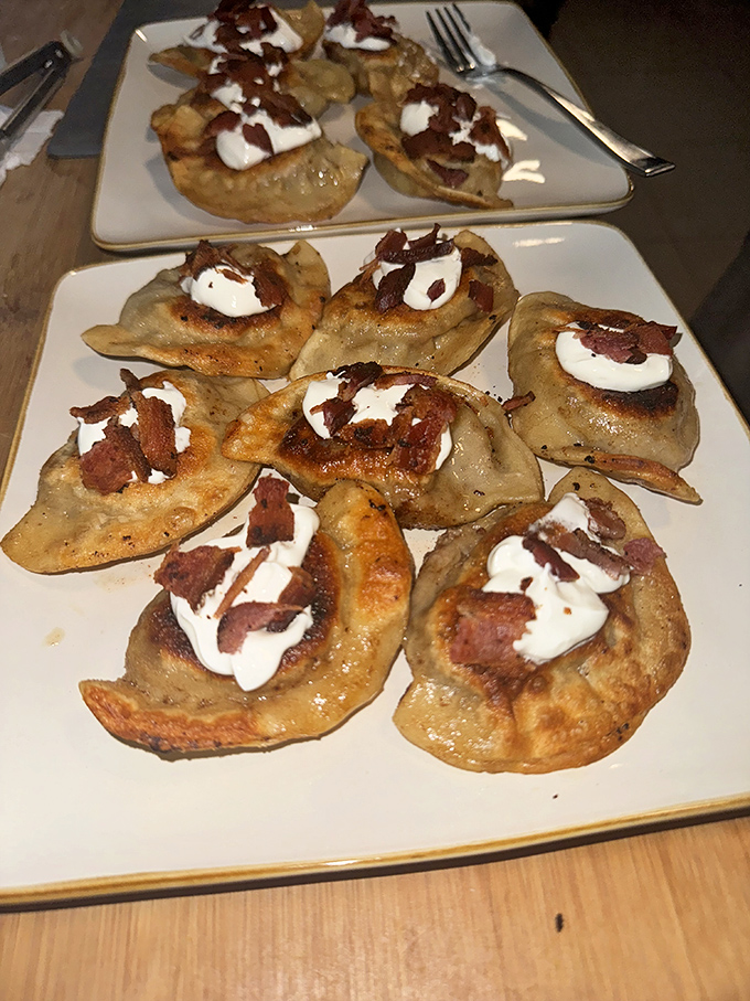 Golden-brown pierogies topped with bacon bits and sour cream&mdash;proof that heaven exists and it's shaped like a half-moon dumpling.