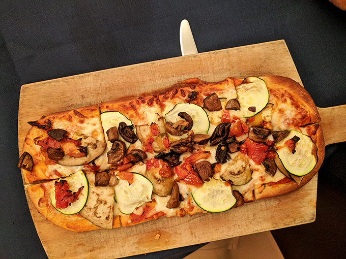This isn't just pizza; it's a carefully composed edible masterpiece where zucchini, mushrooms, and tomatoes perform a flavor symphony.