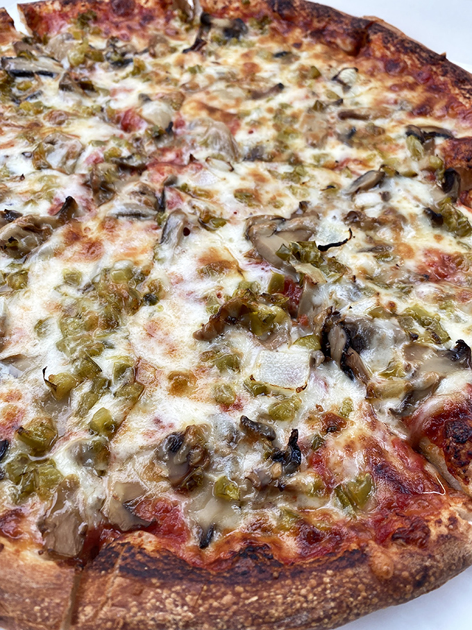 This isn't just pizza—it's a masterclass in balance. Those mushrooms and peppers aren't just toppings; they're participating in a flavor summit.