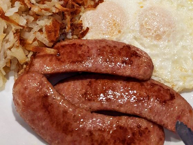 The Polish sausage arrives with a glorious snap, glistening with promise beside perfectly crispy hash browns and sunny-side-up eggs.