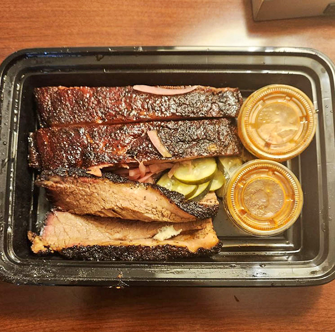 Brisket with that textbook smoke ring and bark that would make a Texan weep with joy. Those pickle chips aren't just garnish&mdash;they're essential acid balance.