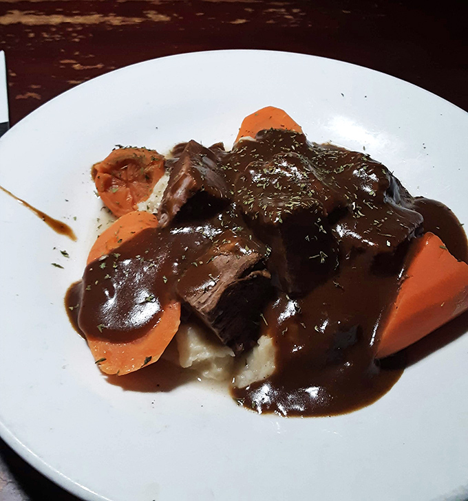 Behold the star attraction: pot roast so tender it practically surrenders to your fork, swimming in a gravy that deserves its own fan club.