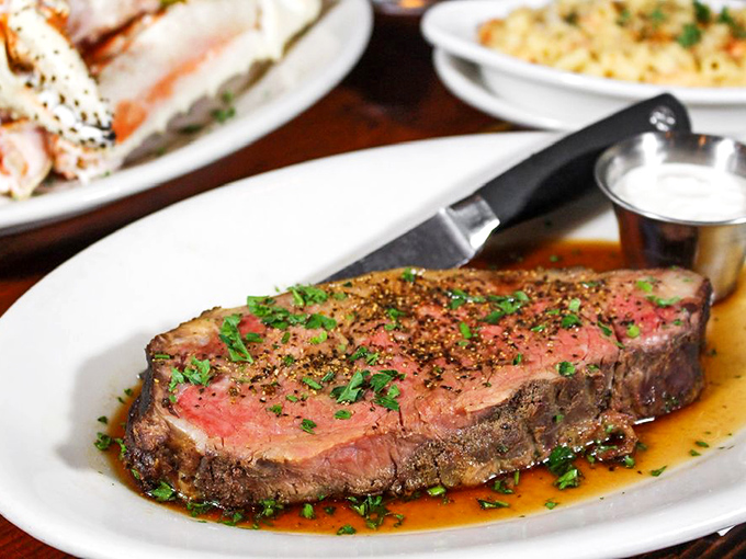 The prime rib arrives like royalty on a white throne, perfectly pink and glistening with juices that whisper, "Worth every calorie."