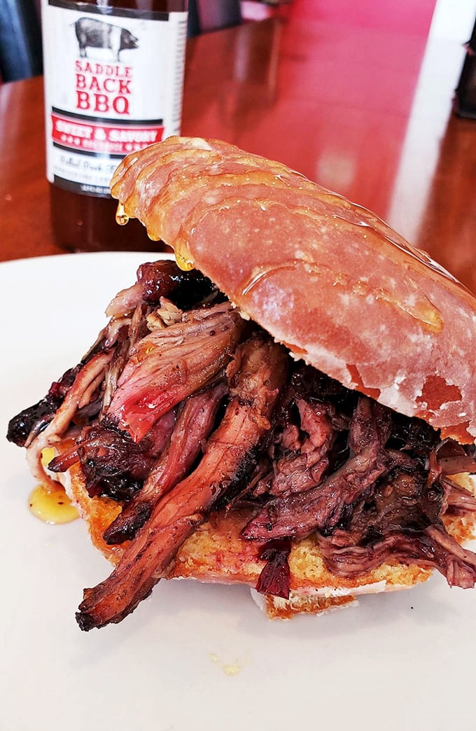 This pulled pork sandwich isn't just food&mdash;it's architecture. The golden-brown bun barely containing a tumble of bark-flecked meat that's practically begging you to unhinge your jaw.