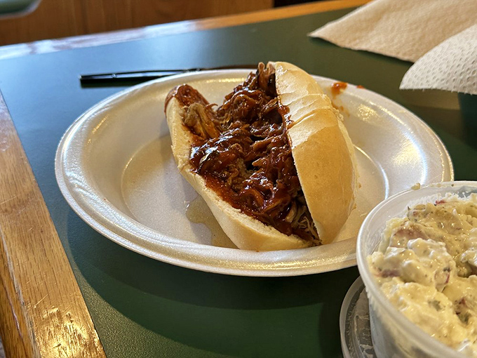 Behold: the pulled pork sandwich in its natural habitat. That glistening sauce-soaked meat nestled in a fresh roll is what barbecue dreams are made of.