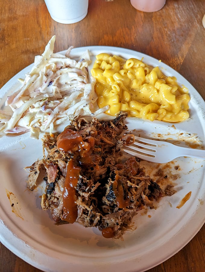 The holy trinity of barbecue perfection: pulled pork with just the right bark, creamy mac and cheese, and coleslaw that cuts through the richness like a well-timed joke.