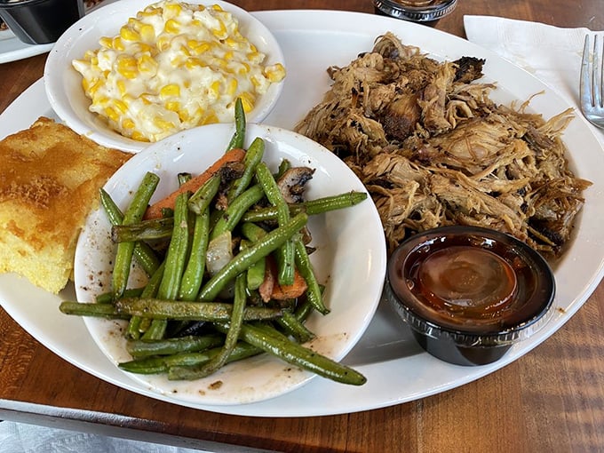 Behold the holy trinity of barbecue perfection: tender pulled pork, vibrant green beans, and creamy corn casserole that would make your grandmother jealous.