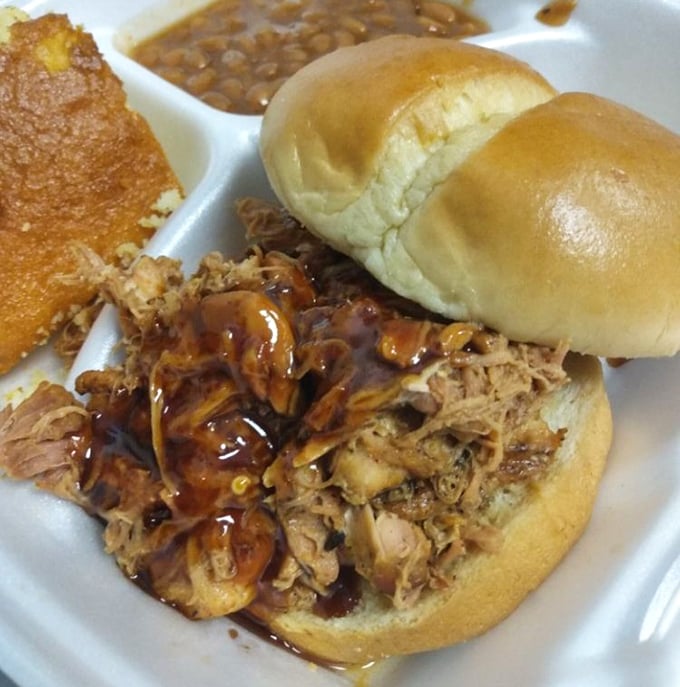 Pulled pork perfection: tender strands of smoky meat glistening with sauce, nestled on a bun that somehow contains this magnificent mess.