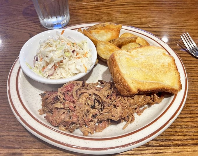 Tender strands of pulled pork alongside creamy coleslaw and Texas toast&mdash;a holy trinity of Southern comfort that speaks directly to your soul.