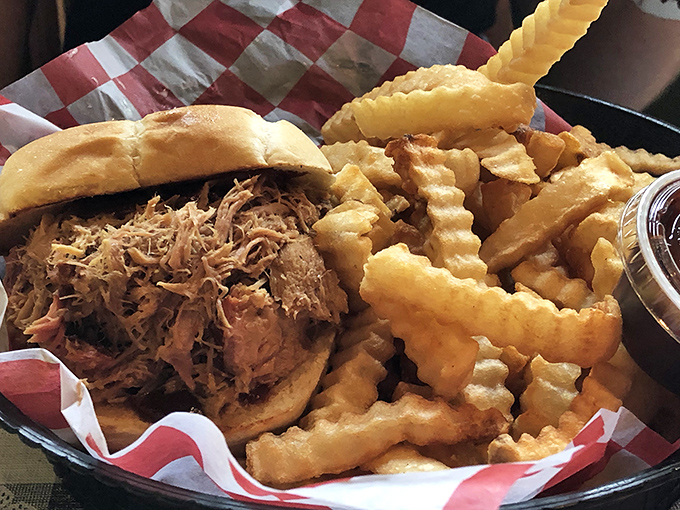 Behold the star of our show: pulled pork piled high on a sturdy bun with crispy fries standing guard. Napkins required, regrets impossible.