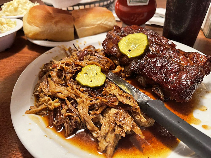 Pulled pork that surrenders at the touch of a fork, paired with ribs that demand your full attention. The pickle slices aren't just garnish&mdash;they're essential acid relief.