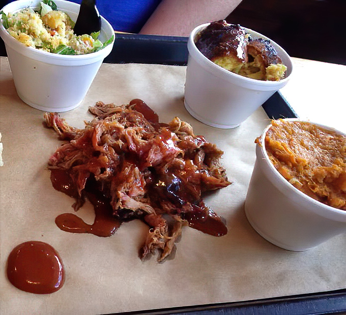 Pulled pork that doesn't just fall apart – it practically writes love sonnets on your taste buds while those sides stand by as worthy companions.