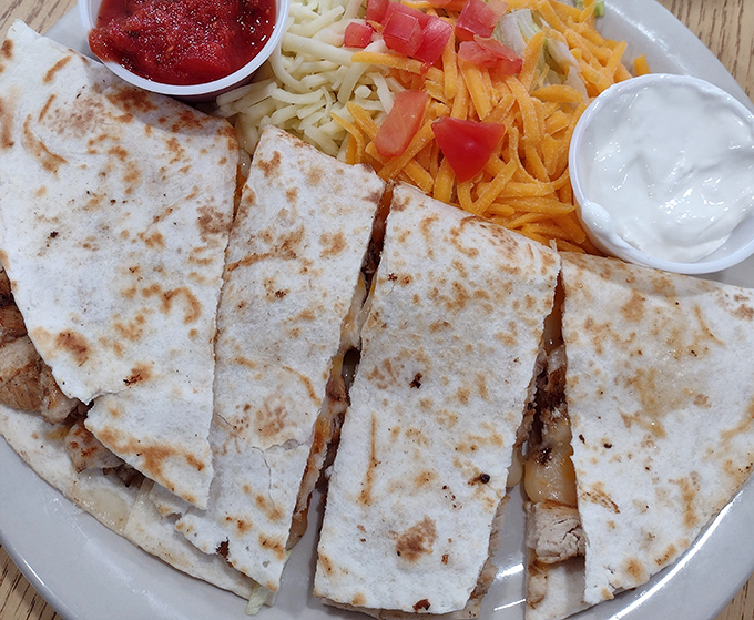 Behold the star attraction: perfectly browned tortilla, melted cheese that stretches like a yoga instructor, and sides that know their supporting role. 
