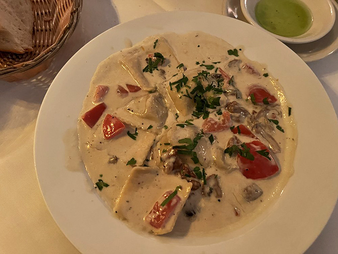 Pillows of pasta perfection! These ravioli swim in a creamy sauce dotted with fresh tomatoes and mushrooms &ndash; comfort food that hits all the high notes.