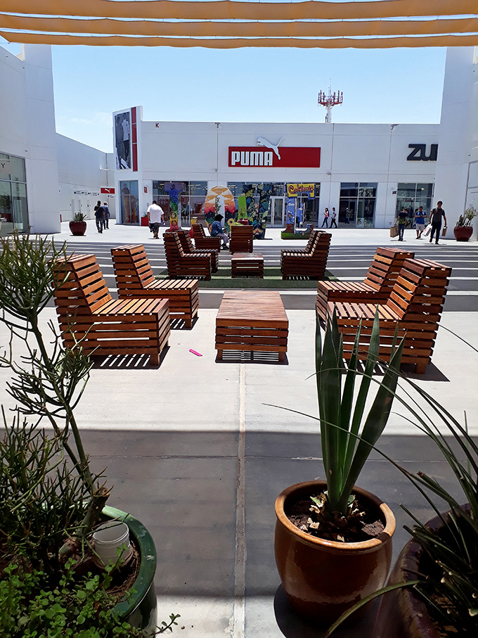 These wooden lounging areas aren't just seating&mdash;they're relationship-saving zones where one partner can recharge while the other continues the shopping marathon.