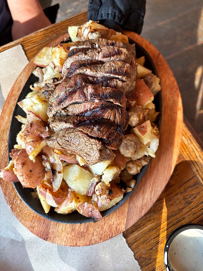 Behold the star of the show: perfectly grilled steak medallions resting on a bed of potatoes like royalty on a throne.