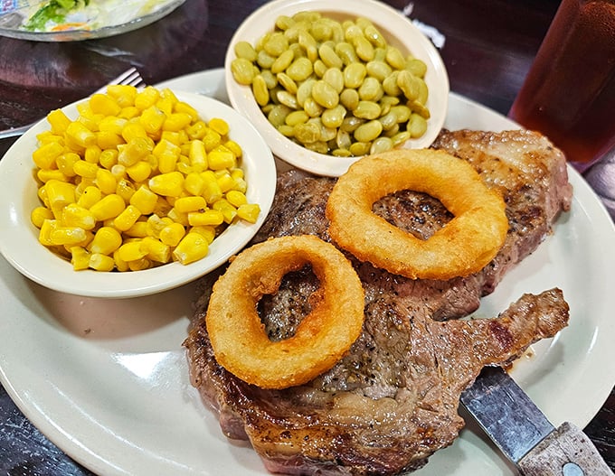 This ribeye isn't just a steak, it's a masterpiece with onion rings as halos – proof that heaven exists on a white plate.