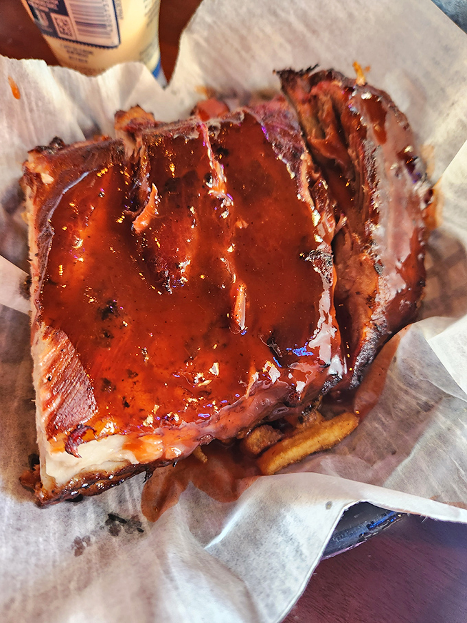 Behold the star of the show: ribs glistening with that signature sauce. That beautiful smoke ring isn't just for show&mdash;it's a pink badge of barbecue honor.