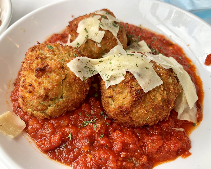 Golden orbs of happiness! These risotto balls achieve that mythical balance of crispy exterior and creamy interior, with shaved parmesan adding the perfect finishing touch.