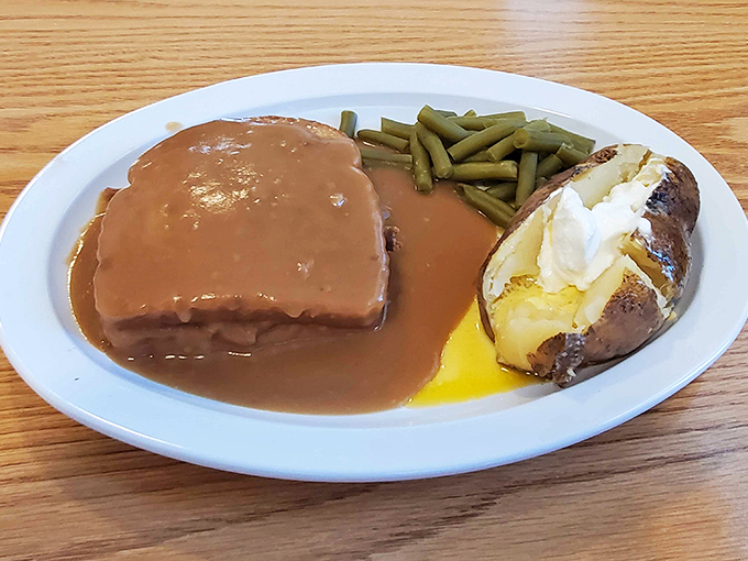 Behold the roast beef dinner in all its gravy-laden glory. That baked potato, split and dressed, sits like royalty alongside green beans that haven't forgotten their purpose in life.