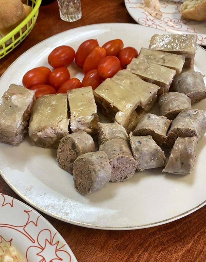 Behold the star attraction: Romanian sausage and headcheese with cherry tomatoes. This plate isn't just food&mdash;it's cultural heritage served with pride.