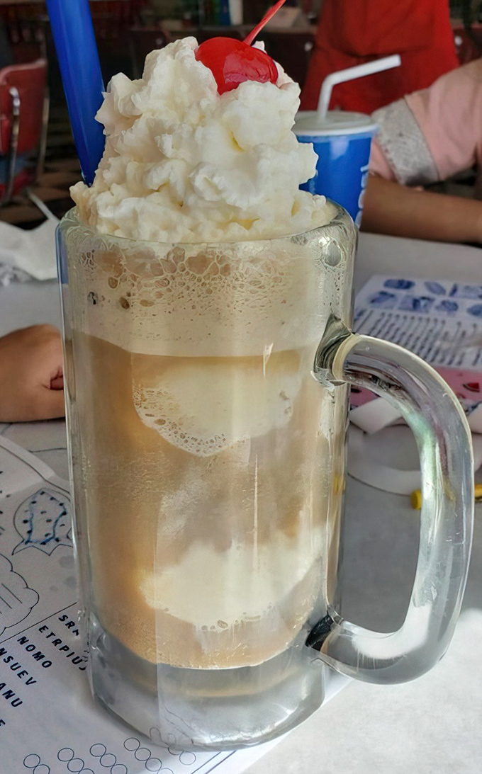 The legendary root beer float arrives like a frothy masterpiece. That perfect moment when ice cream meets soda &ndash; childhood bliss in a frosted mug.