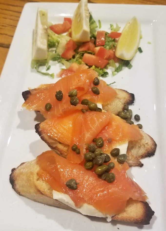 The legendary salmon bruschetta arrives like edible artwork &ndash; smoky bread, velvety salmon, and those tiny capers providing little flavor fireworks in every bite.