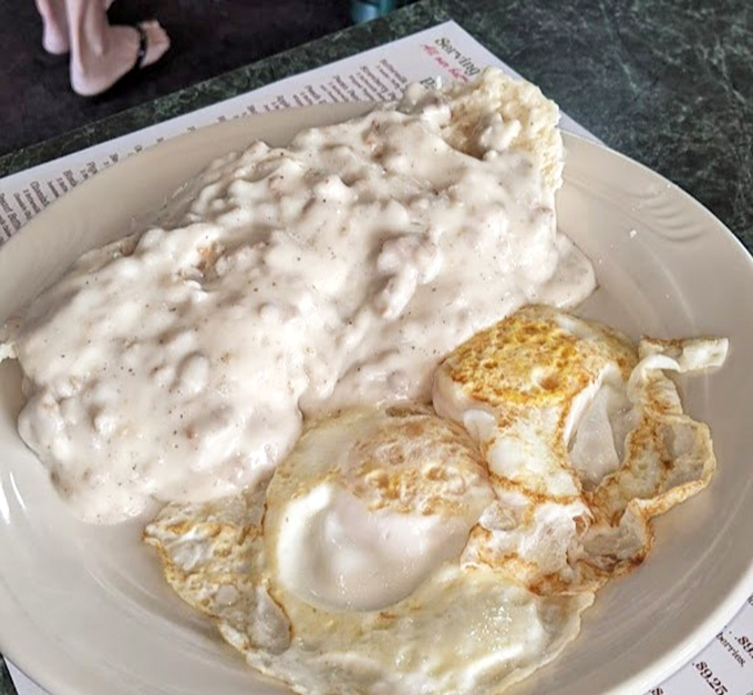 Behold the star attraction: sausage gravy that doesn't just cover the biscuit&mdash;it embraces it in a peppery, creamy bear hug.