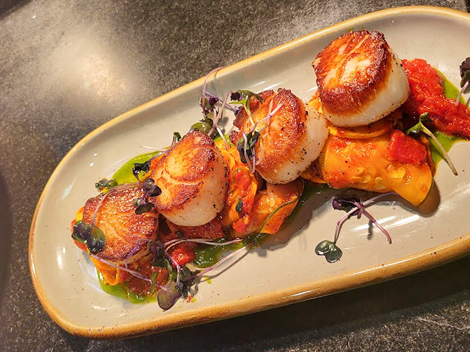 These perfectly seared scallops aren't just cooked &ndash; they're transformed into buttery medallions of oceanic bliss on a colorful canvas.