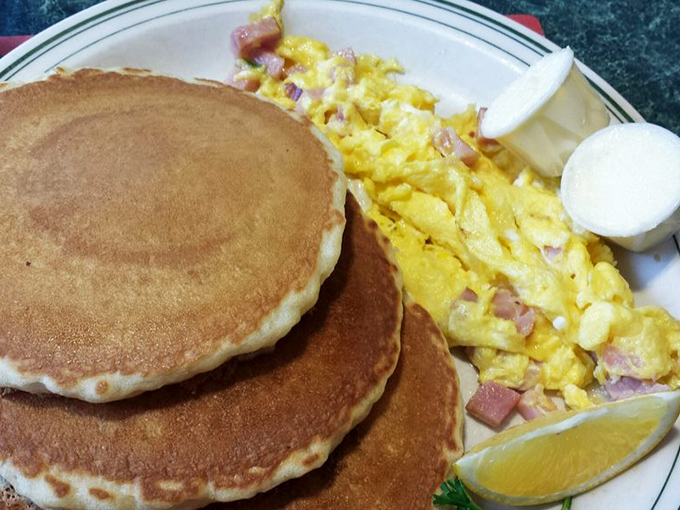 Golden pancakes with a side of scrambled eggs that look like they've been whispered into perfection. That hint of ham adds just the right savory note.