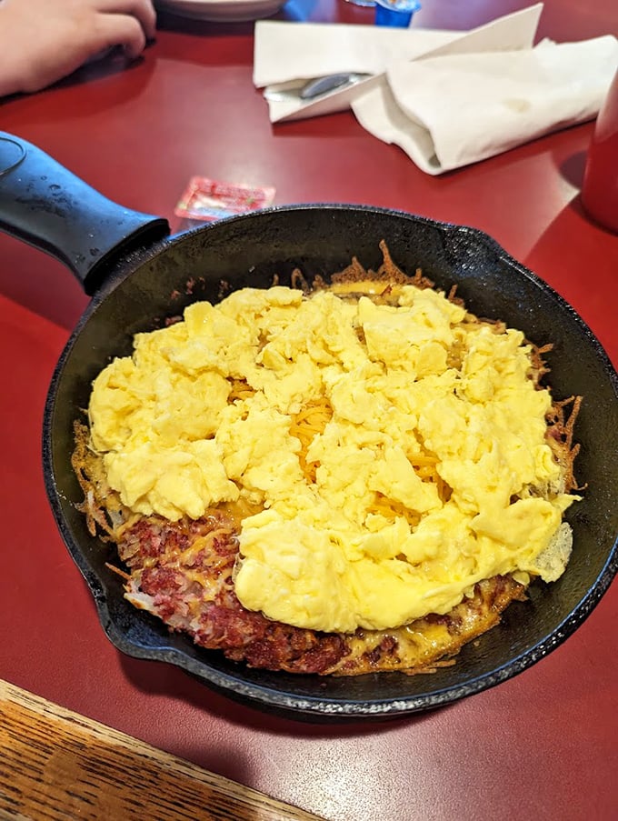 Behold the star attraction &ndash; scrambled eggs nestled atop a bed of hash browns in a cast-iron skillet. Breakfast perfection achieved!
