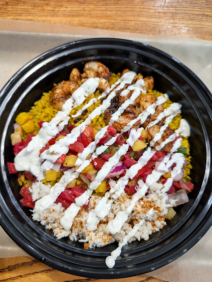 A seafood bowl that's basically Florida sunshine in edible form. The white sauce zigzags aren't just decoration&mdash;they're flavor lightning bolts that tie everything together.