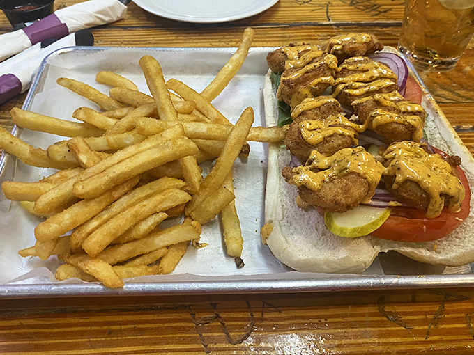 This isn't just a sandwich; it's an architectural masterpiece of golden-fried shrimp, melty cheese, and crispy fries that demands both hands and your full attention.