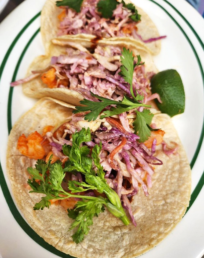These shrimp tacos arrive dressed to impress &ndash; purple cabbage confetti and cilantro crowns making each bite a celebration.