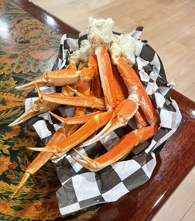 Snow crab legs arranged like a delicious game of pick-up sticks. The checkered paper says "casual," but the meat inside whispers "luxury."