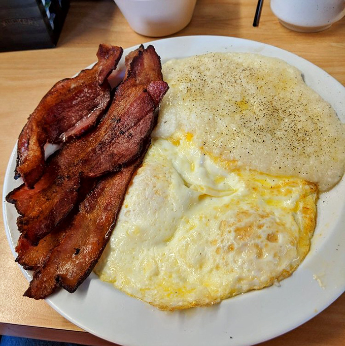 Crispy bacon, sunny-side-up eggs, and creamy grits &ndash; the holy trinity of Southern breakfast executed to perfection.