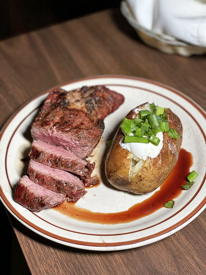 The star of the show: a perfectly medium-rare steak with a baked potato standing by. This isn't just dinner&mdash;it's a life event.
