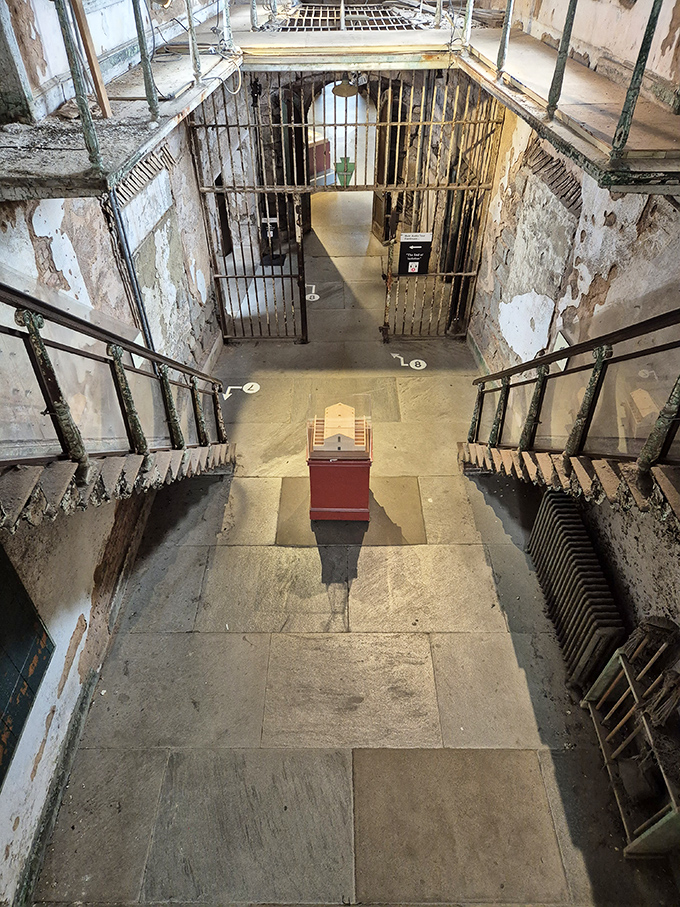 Descending these stairs meant entering a different world. The contrast between light above and shadows below perfectly captures Eastern State's psychological impact.