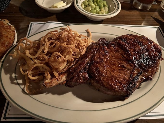 This isn't just a steak; it's a masterclass in simplicity. Perfect crust, medium-rare interior, and those onion rings deserve their own fan club.