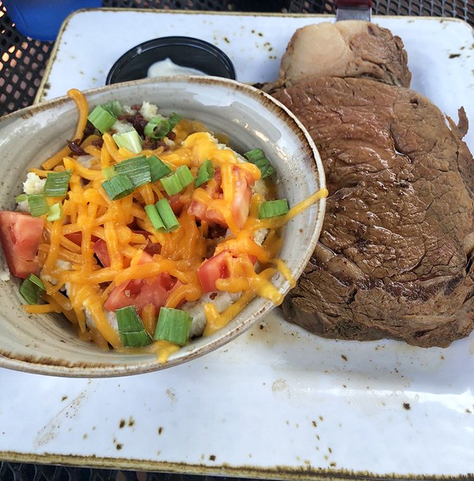 Behold the star of the show – a perfectly cooked steak alongside a loaded baked potato that's practically wearing jewelry with all those toppings.