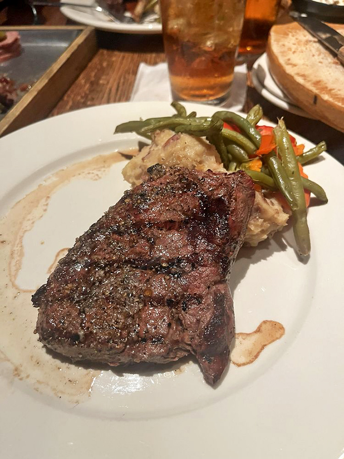 This perfectly seared steak with its caramelized crust is the reason vegetarians have second thoughts. Meat poetry on a white plate.