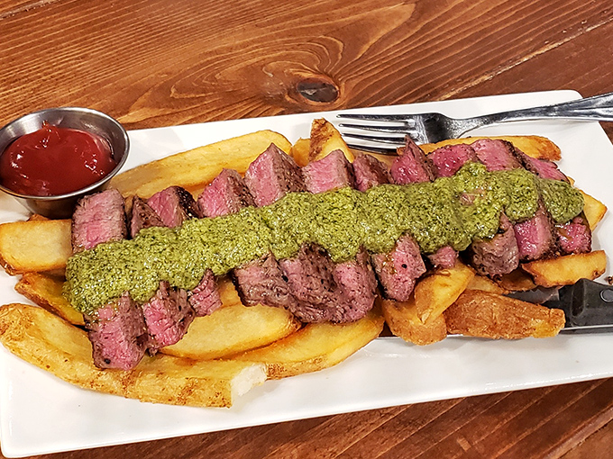 Behold the star attraction: perfectly cooked steak frites with vibrant green sauce that makes you want to cancel all other dinner plans indefinitely.