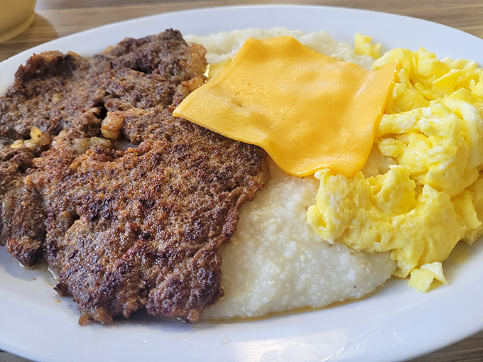 Behold the holy trinity of breakfast perfection: seasoned steak with a perfect sear, creamy grits that whisper "y'all come back now," and eggs that sunshine your plate.