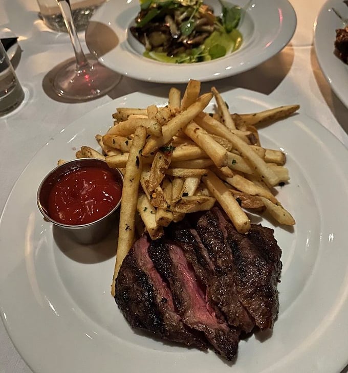 Behold the steak frites in all its glory – a perfectly seared flat iron steak alongside fries that deserve their own fan club.