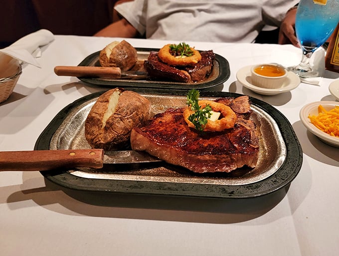 Steak perfection arrives on sizzling platters that announce themselves before they're even visible. That onion ring crown is the tiara this beef royalty deserves.