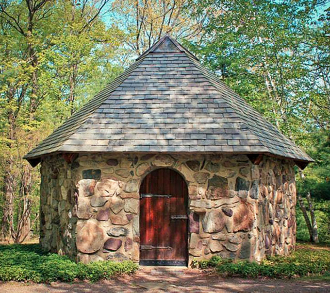 Rustic stone cottage with a storybook red door. The kind of place hobbits would build if they decided to upgrade from underground dwellings.