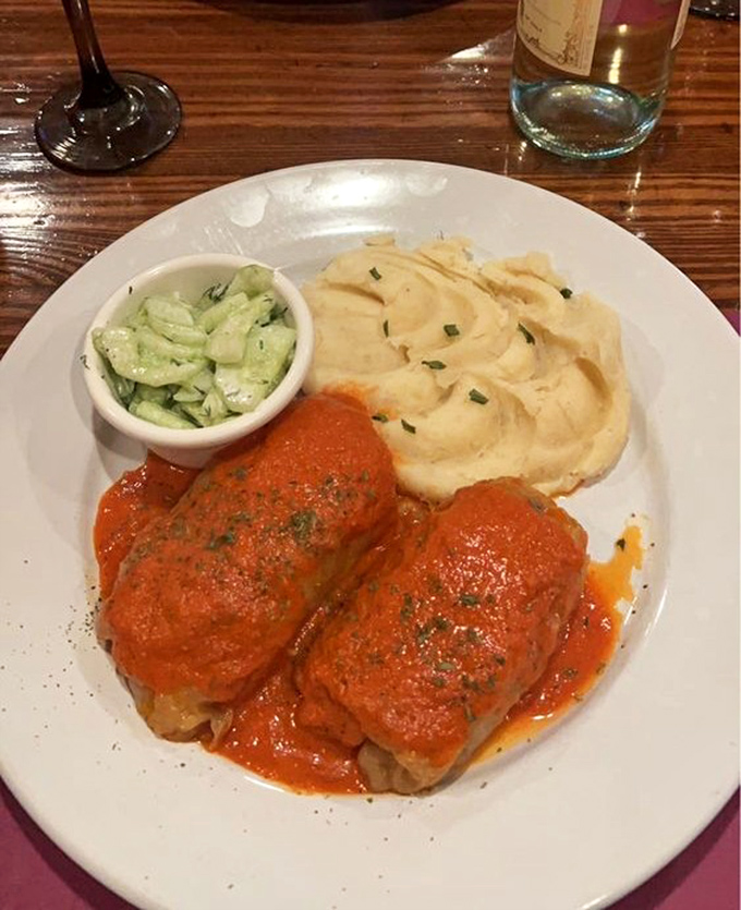 Behold the star attraction: stuffed cabbage bathed in that vibrant sauce with creamy mashed potatoes. This isn't food; it's edible therapy.