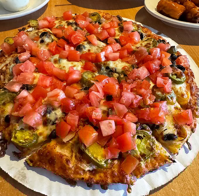 Fresh diced tomatoes cascade over melted cheese and jalape&ntilde;os like confetti at a flavor parade. This pizza doesn't just cross borders&mdash;it demolishes them.